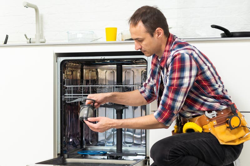 Worker Repairing the Dishwasher in the Kitchen Stock Photo - Image of ...