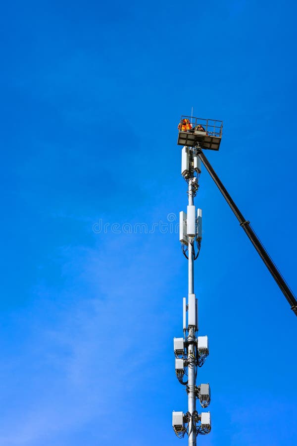 A Worker Repairs a Cell Tower while Standing in a Manipulator Cradle ...