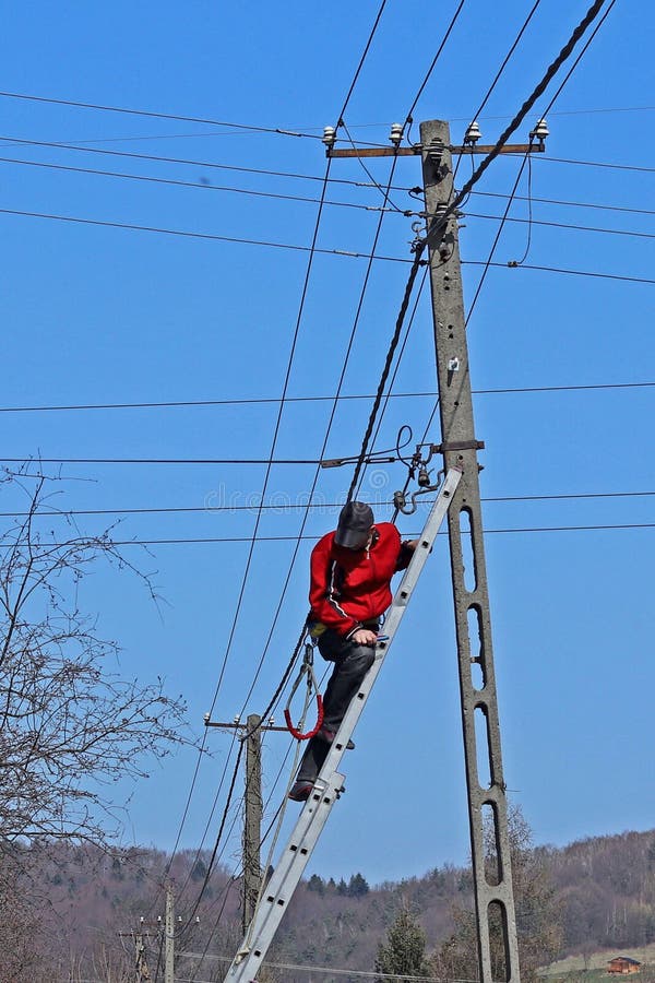 The Worker Repairs the Wiring on the Pole, Climbing the Attached ...