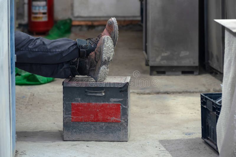 Worker Rests in the Workshop with His Feet on a Box Stock Photo - Image ...