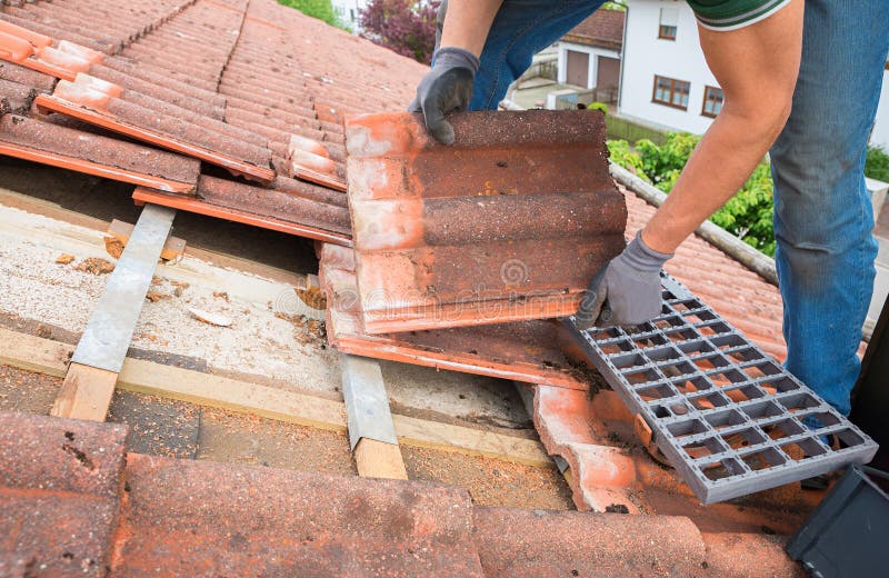 Worker on the Rooftop, Replacing Broken Tiles with New Shingles Stock ...