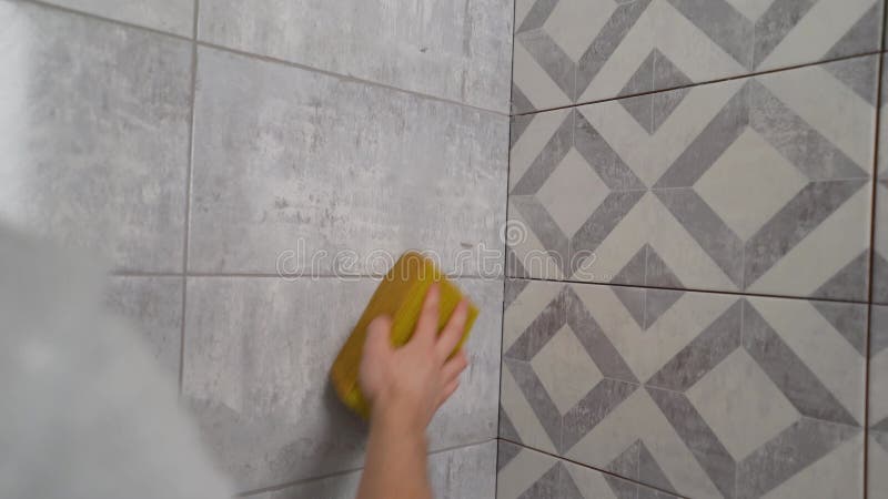 Grout Tiles with a Sponge. the Master Wipes the Tiles after Grouting. a ...