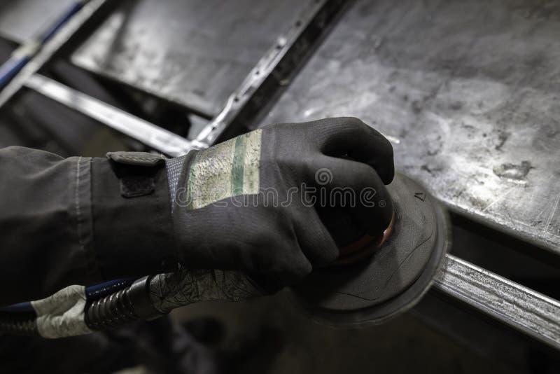 A Worker S Gloved Hand Uses a Power Sander To Smooth the Joints of a ...