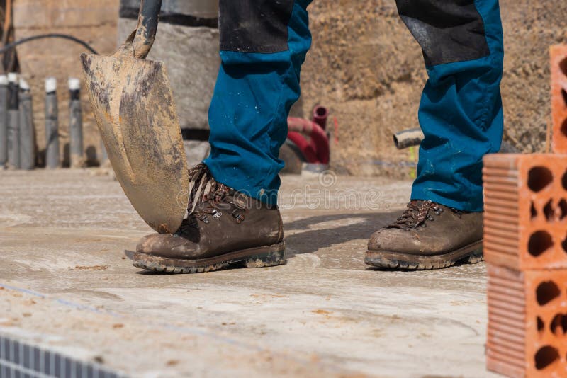 Worker& X27;s Legs in Construction Site with a Shovel on Safety Boots ...