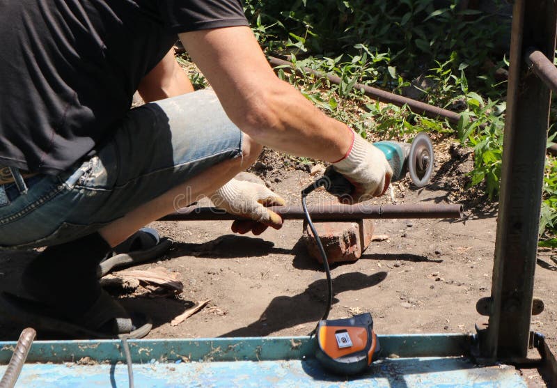 A Worker Sawed Off Part of a Metal Pipe with a Grinder Stock Image ...