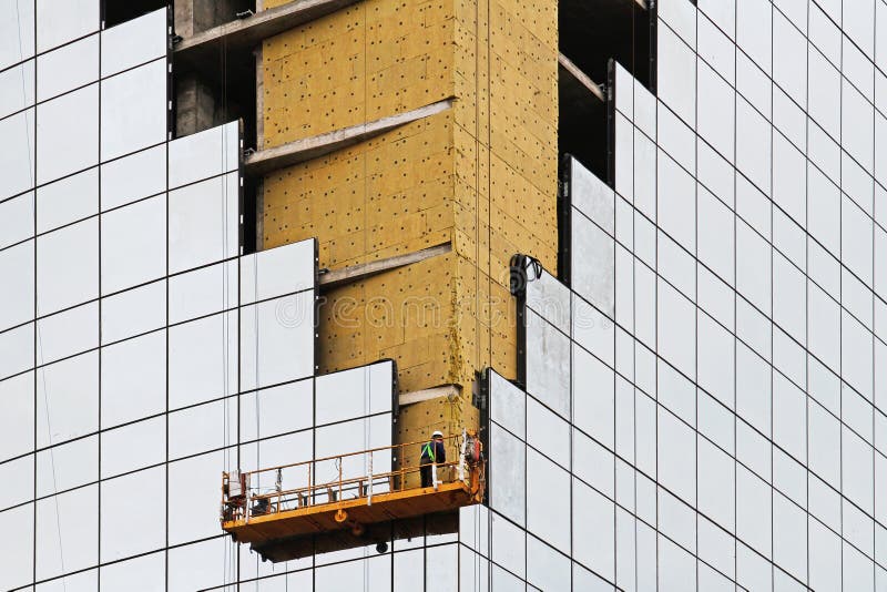 Worker on the Scaffold Elevator Evens Insulation Boards at the Corner ...