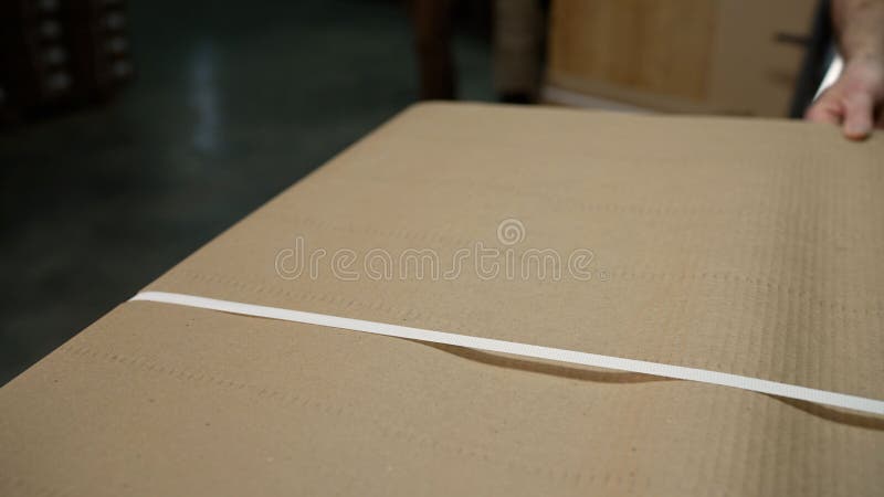 Worker Securing Cardboard Box with Packaging Straps Stock Photo - Image ...