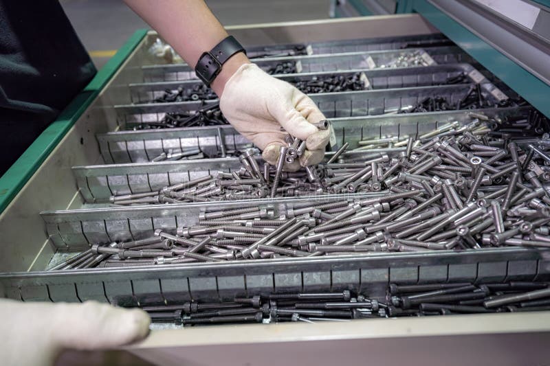 A Worker Selects Bolts in a Box To Connect Technical Parts Stock Photo ...