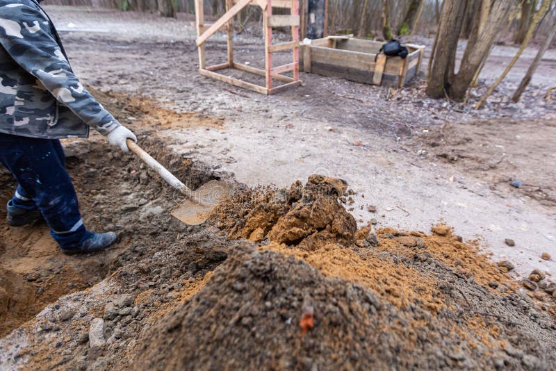 Worker with Shovel is Digging a Pit on Construction Site. Concept of ...