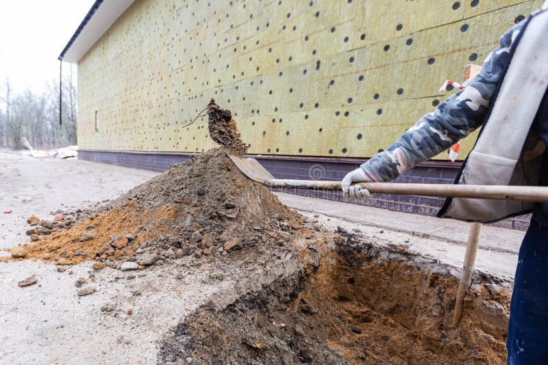 Worker with Shovel is Digging a Pit on Construction Site. Concept of ...