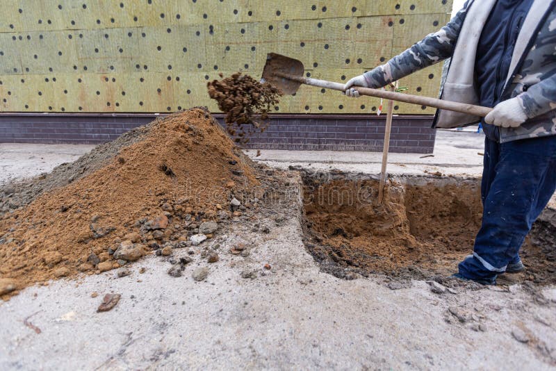 Worker with Shovel is Digging a Pit on Construction Site. Concept of ...
