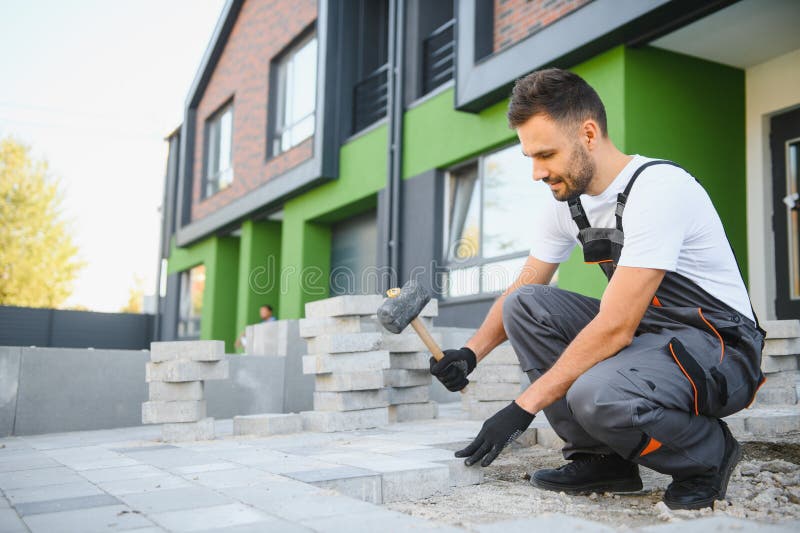 Worker Skillfully Laying Paving Stones Using a Hammer and Wearing ...