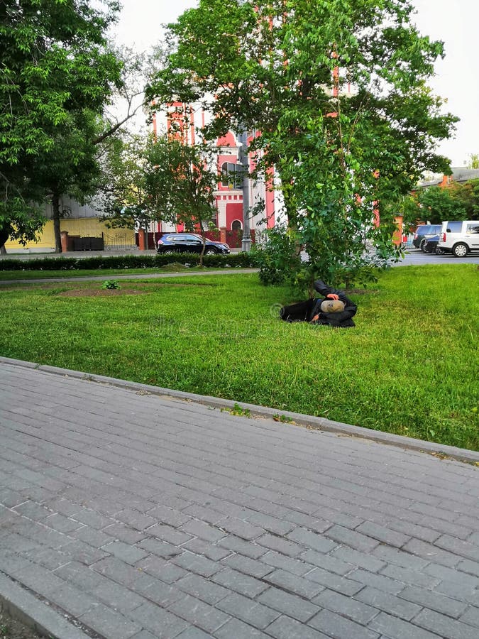 The Worker Sleeps Under the Tree at the Break. Homeless Sleeping on the ...