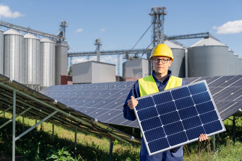 Worker with Solar Panel on a Background of Solar Power Station Stock ...