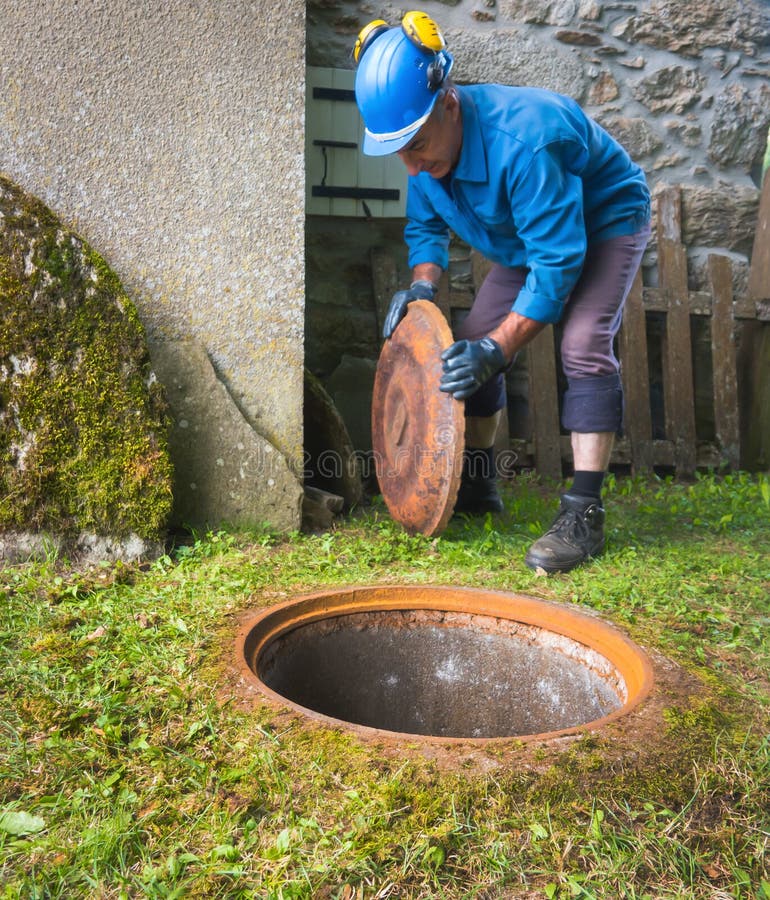 A Worker Opens a Manhole in To Descend Underground Stock Photo - Image ...