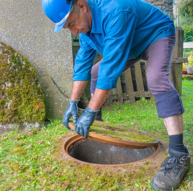 A Worker of Construction Opens a Manhole in To Descend Underground ...