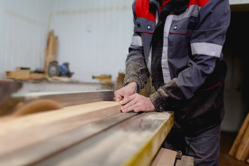 The Worker Spends a Board on Cutting on the Machine Tool. View at an ...