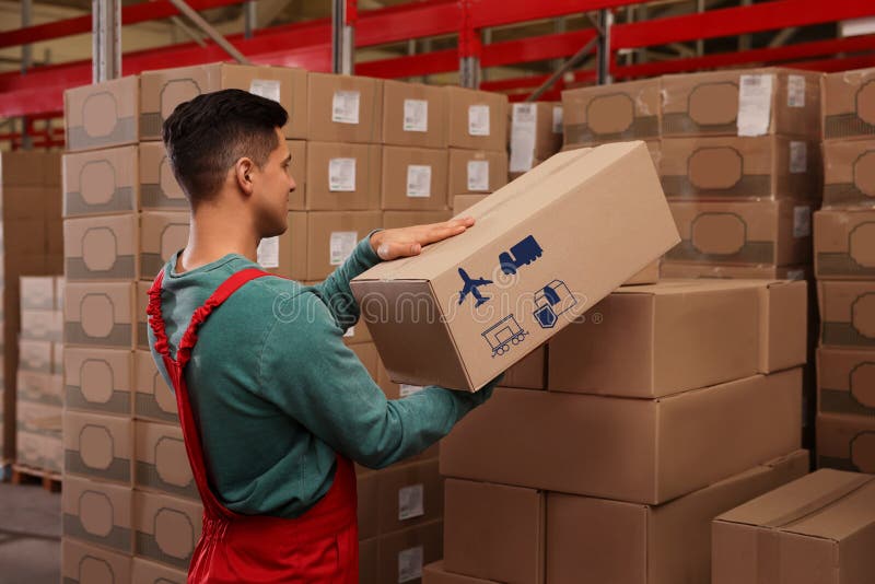 Worker Stacking Cardboard Boxes with Shipping Icons in Warehouse ...