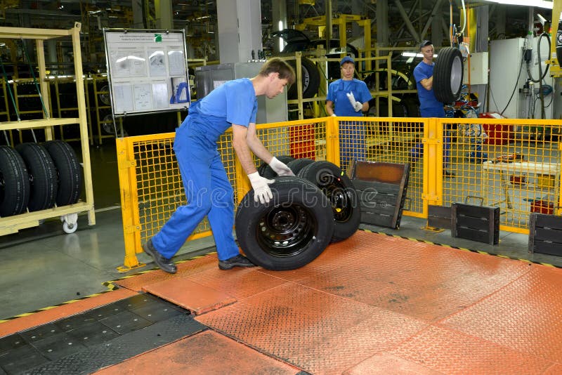 The Worker Stores Automobile Wheels in Assembly Shop. Automobile ...