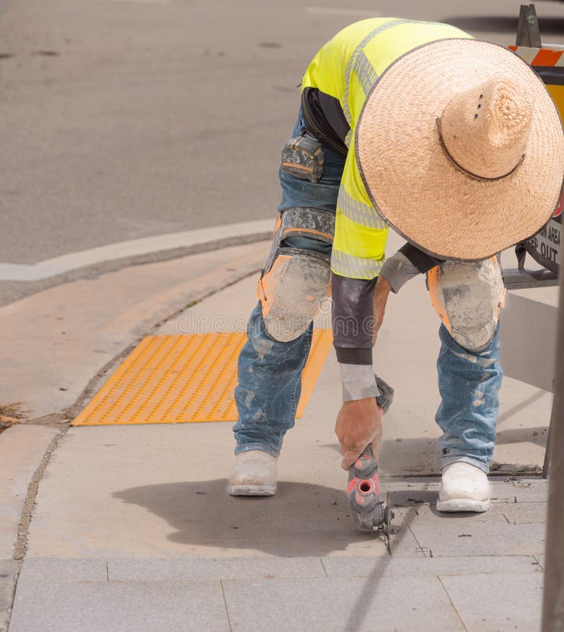 Worker with a Straw Hat Grinding Concrete Walls of the Street Stock ...