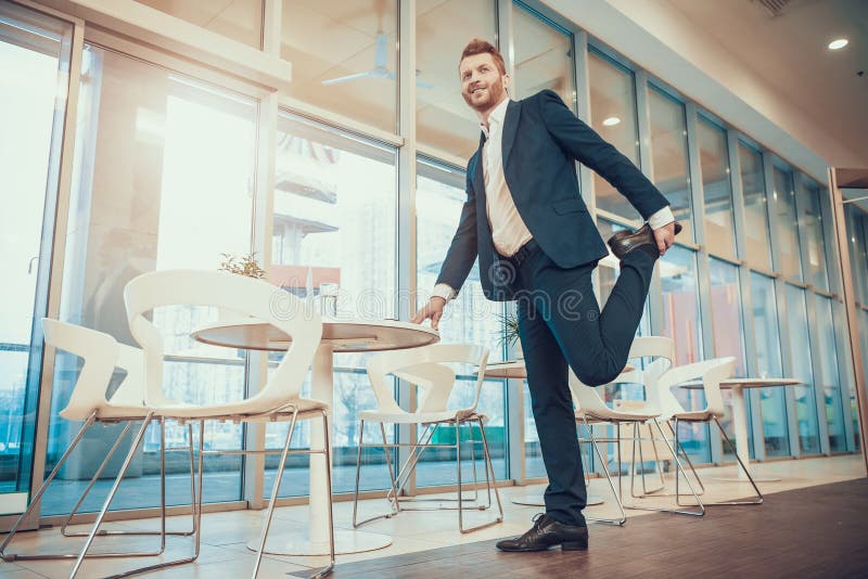 Worker Stretching Leg at Table in Office. Stock Image - Image of ...