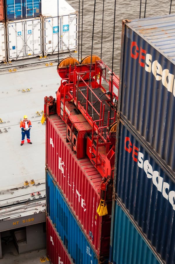Worker Supervising Container Uploading at Dock of a Container Ship ...