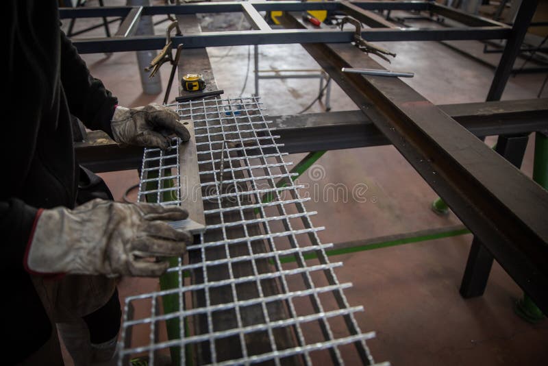 A Worker Takes Measurements of a Grid with a Ruler on the Construction ...