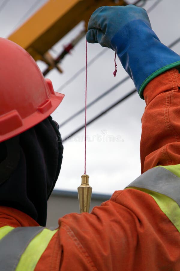 Worker Taking Measurement with a Pendulum Tool on Installation of a ...