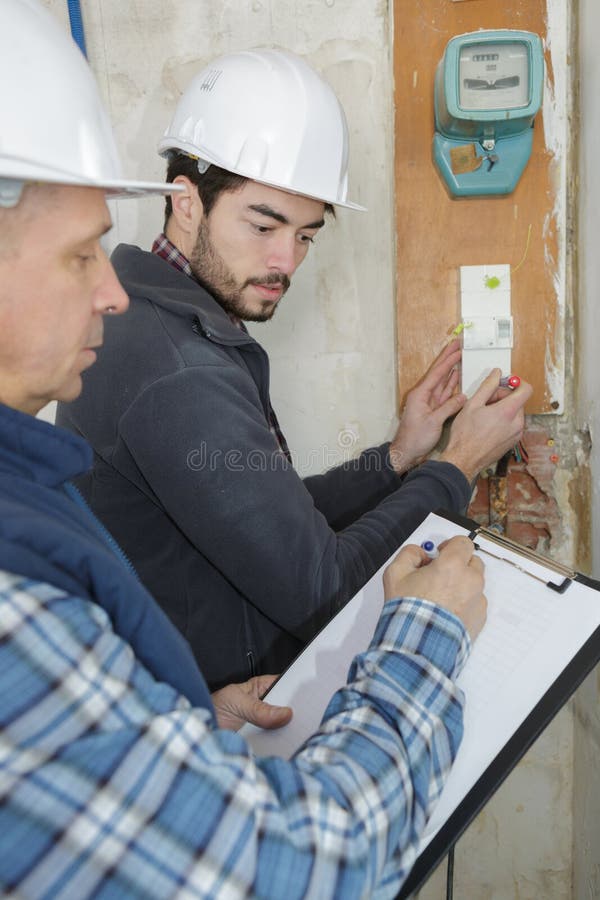 Worker Taking Notes on Clipboard while Taking To Coworker Stock Photo ...