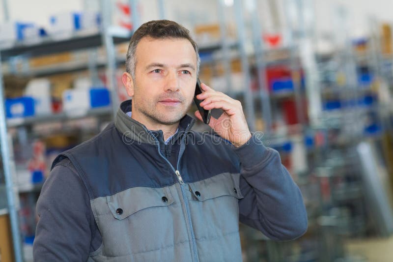 Worker Talking on Cell Phone in Warehouse Stock Image - Image of ...