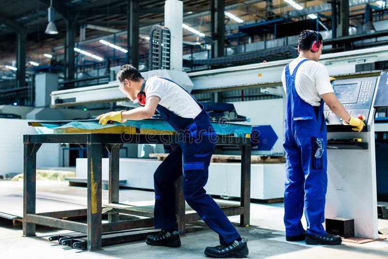 Worker Team in Factory Discussing in Front of Machine Stock Photo ...