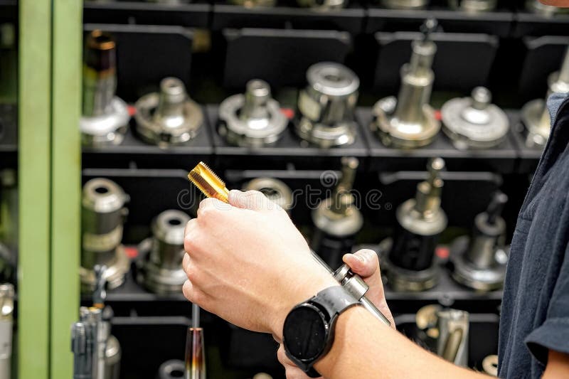 A Worker Inspects and Selects a Drill To Work on a Cnc Milling Machine ...