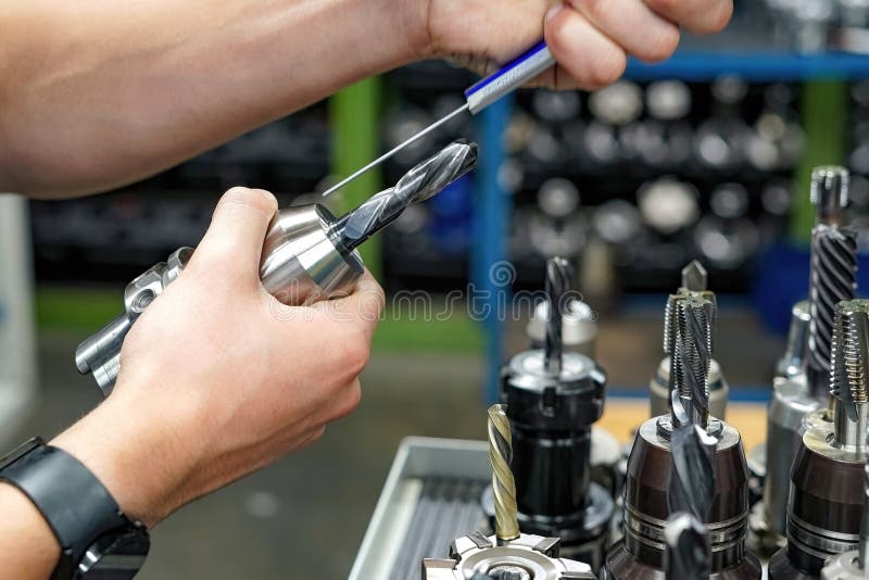 A Worker in a Tool Warehouse Inspects and Selects Cutters for Work on a ...