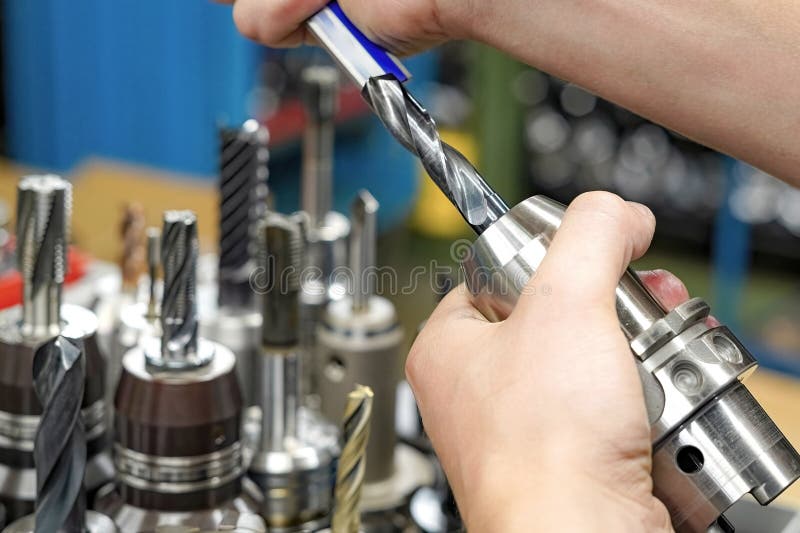 A Worker in a Tool Warehouse Inspects and Selects Cutters for Work on a ...
