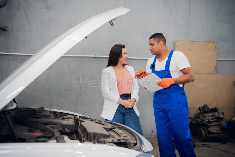 A Worker in Uniform Asks a Customer about a Car Repair Stock Image ...