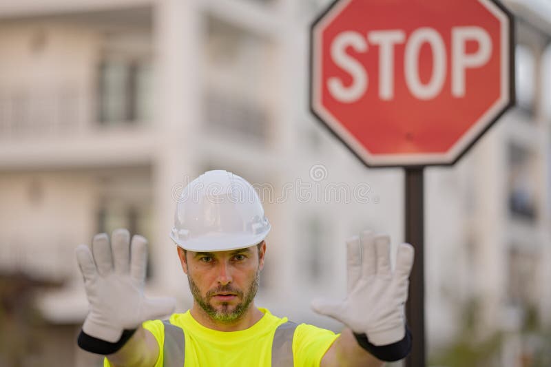 Worker in Uniform Gesturing Stop. Serious Builder with Stop Road Sign ...