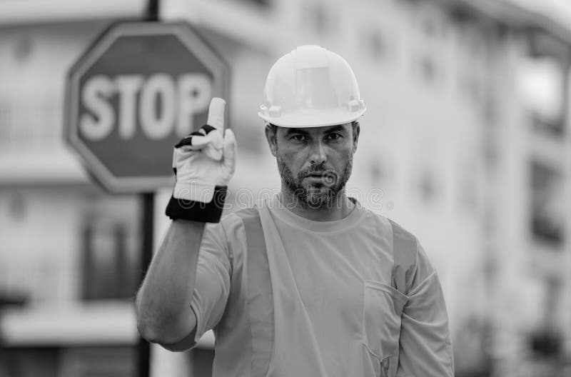 Worker in Uniform Gesturing Stop. Serious Worker with Stop Road Sign ...