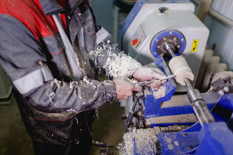 The Worker with a Chisel Gives a Round Shape To the Bar on the Machine ...