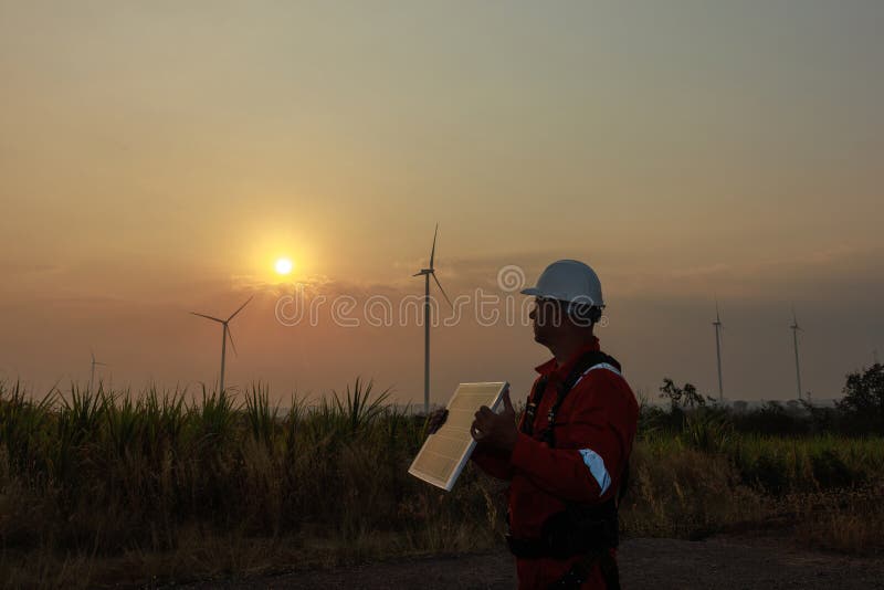 Worker in a Uniform Holding a Solar Panel on a Solar and Wind Turbine ...