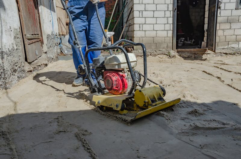 Worker in Uniform and Knee Pads Use Vibratory Plate Compactor for Path ...