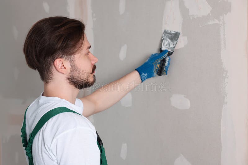 Worker in Uniform Plastering Wall with Putty Knife Indoors Stock Image ...