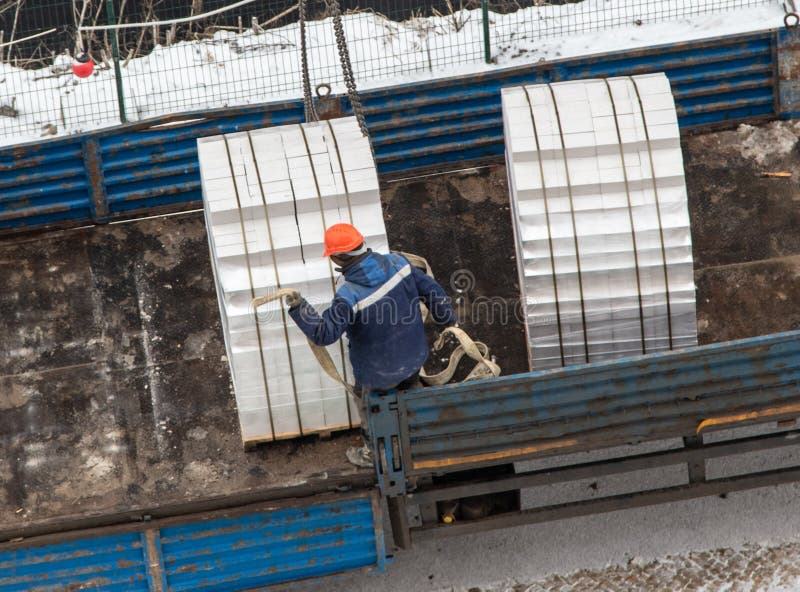 A Worker is Unloading Bricks in a Truck at a Construction Site Stock ...