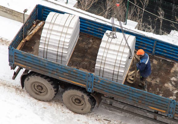 A Worker is Unloading Bricks in a Truck at a Construction Site Stock ...