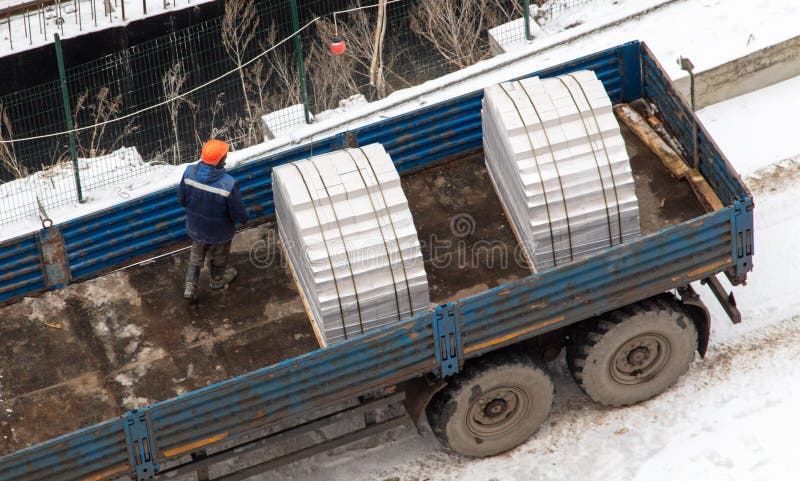 A Worker is Unloading Bricks in a Truck at a Construction Site Stock ...