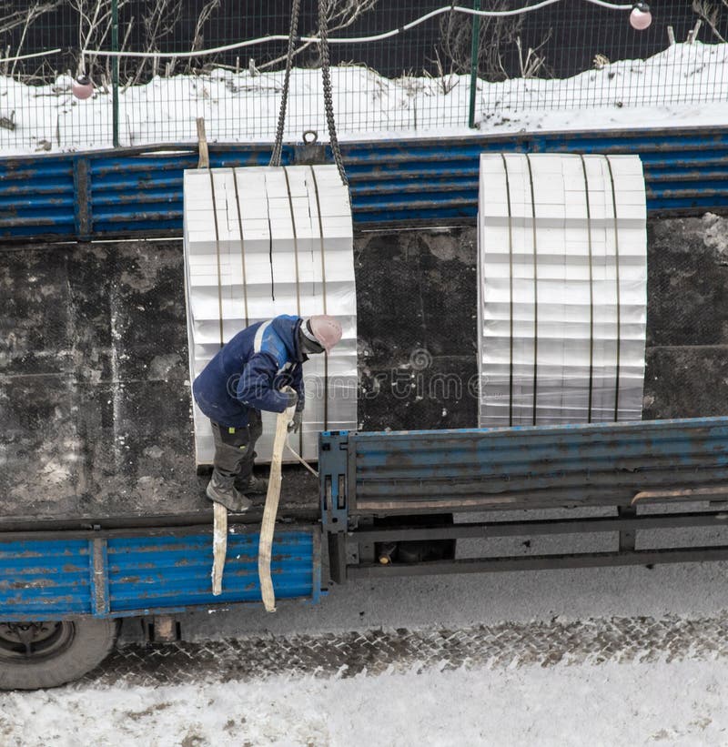 A Worker is Unloading Bricks in a Truck at a Construction Site Stock ...