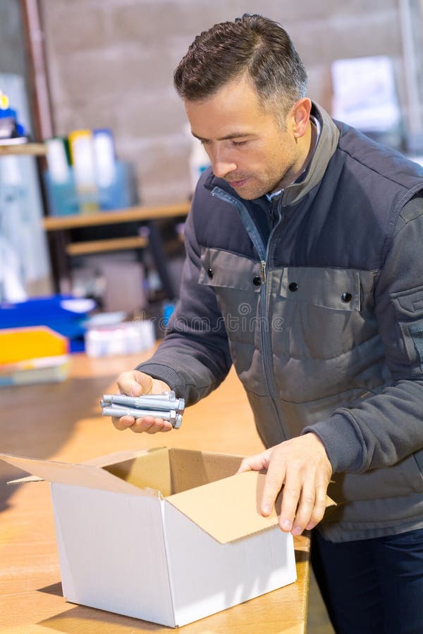 Worker Unpacking Bolts from Delivery in Cardboard Box Stock Photo ...