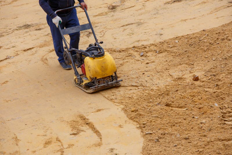 Worker in Use Vibratory Plate Compactor for Compaction Sand during Path ...