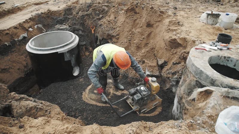Worker Use Plate Compactor on Macadam in Ditch with Concrete Manhole ...