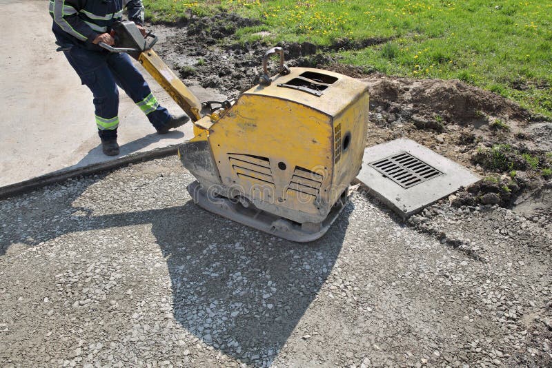 Worker Use Vibratory Plate Compactor at Road Construction Site Stock ...