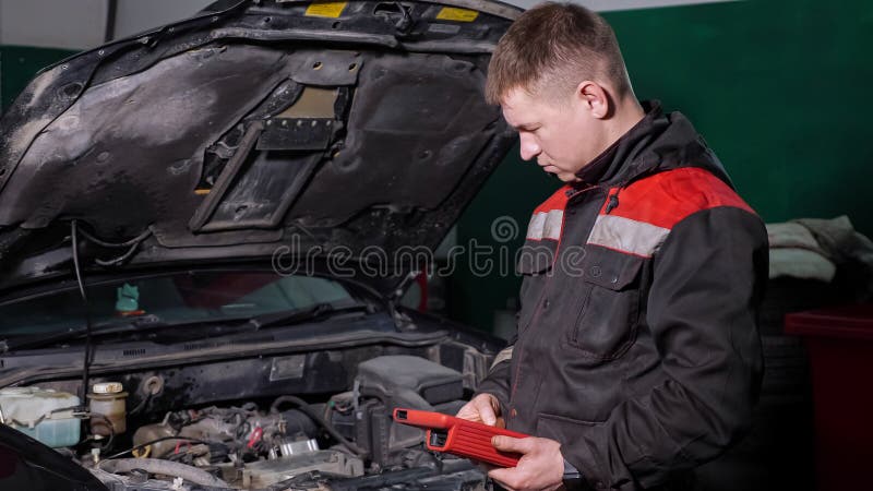 Worker Uses Digital Device To Check Automobile at Station Stock Image ...